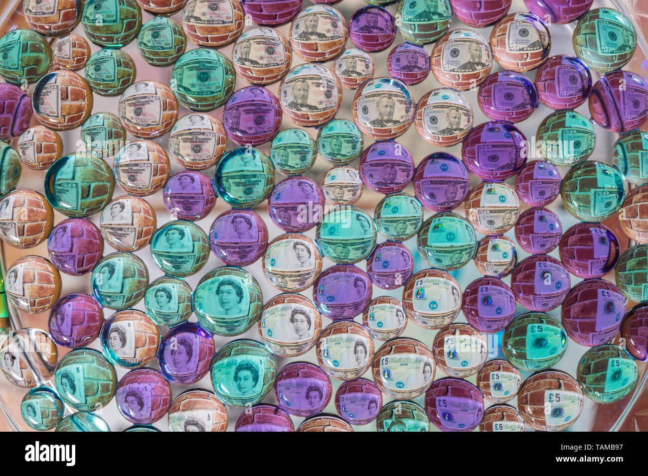 5 pound british note with 50 usd bill refracted through marble-sized ...
