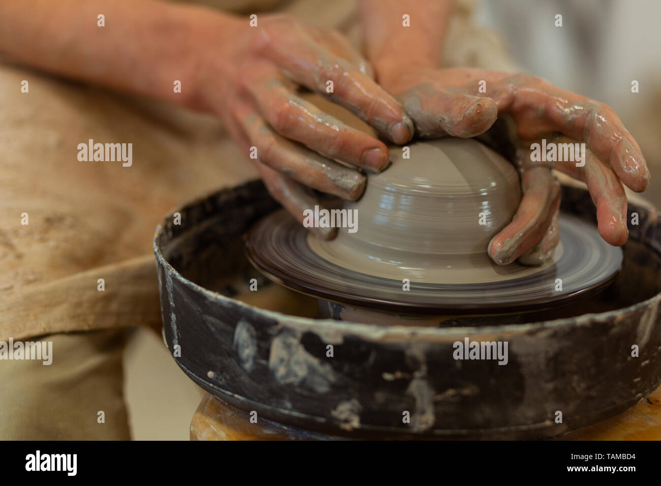 Producing on wheel. Talented accurate man being professional pottery ...