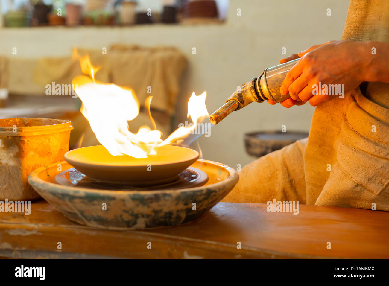 Setting on fire. Strong calm man holding special burning tool for ...