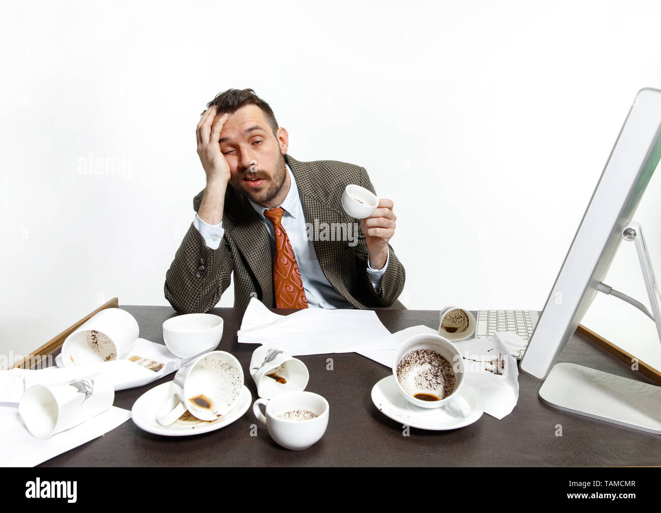 Has no time for resting. Young man drinking a lot of coffee, but can't ...