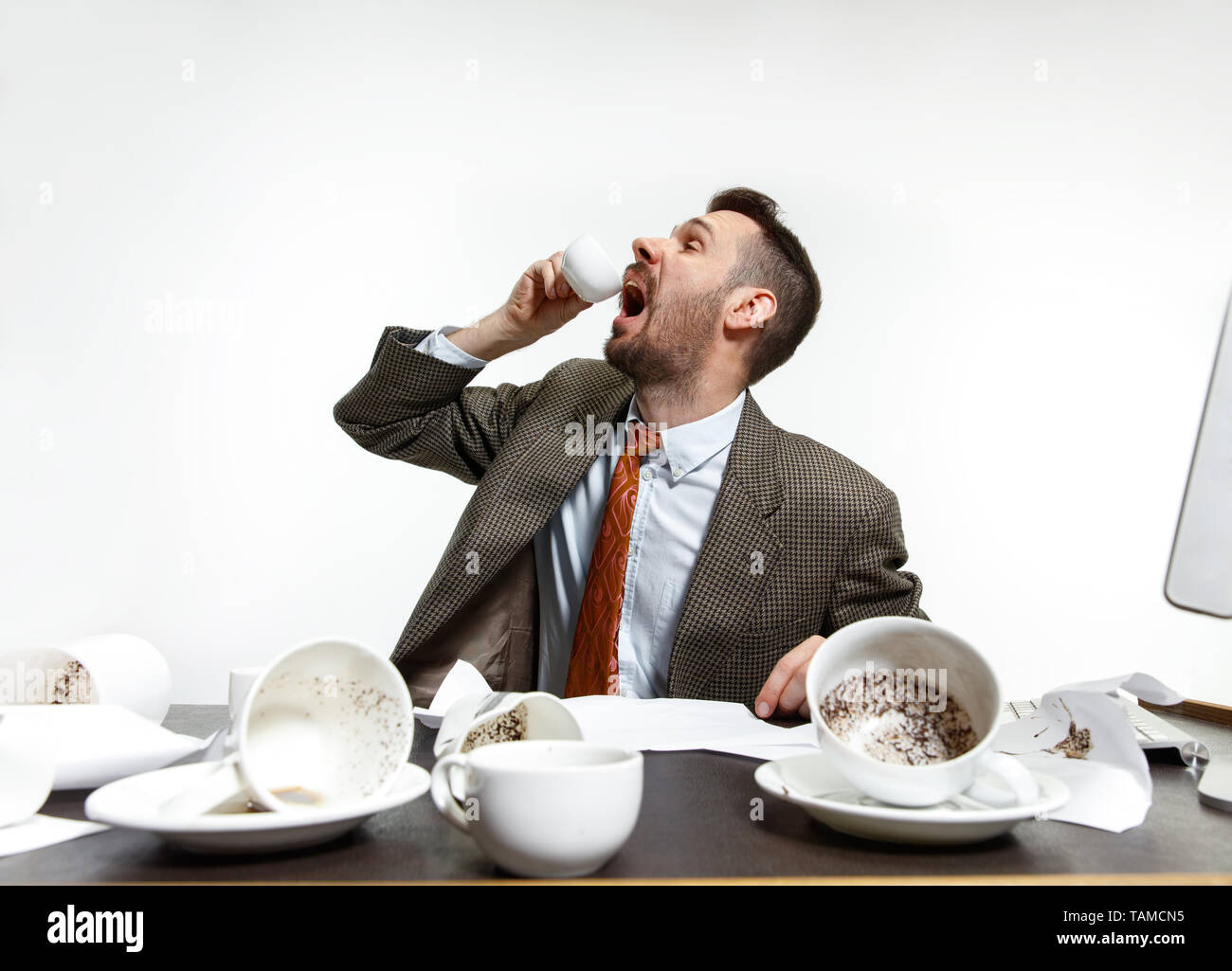 Has no time for resting. Young man drinking a lot of coffee, but can't ...