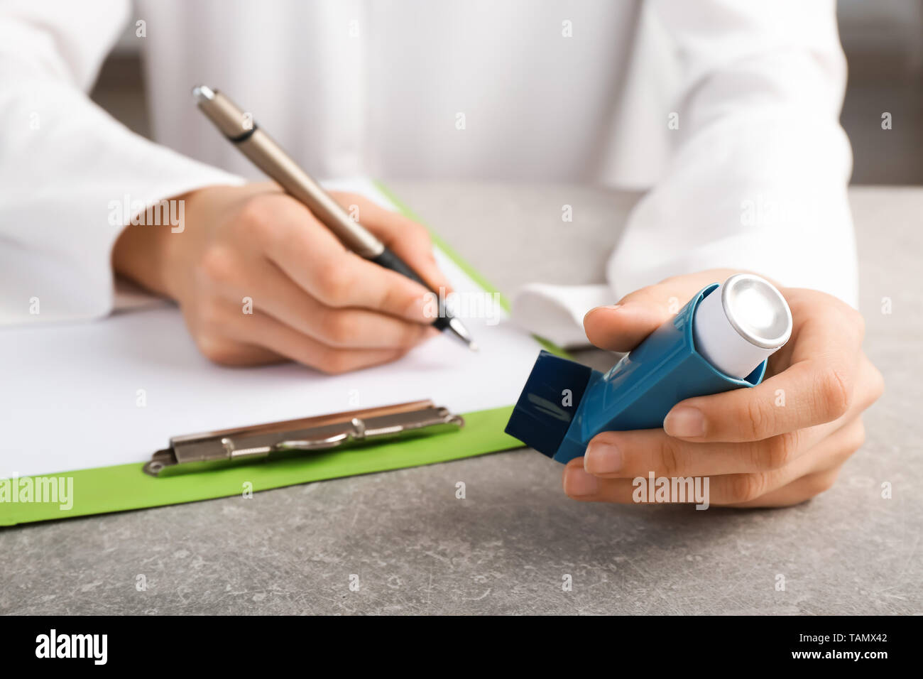 Doctor writing out prescription for using inhaler against asthma Stock ...