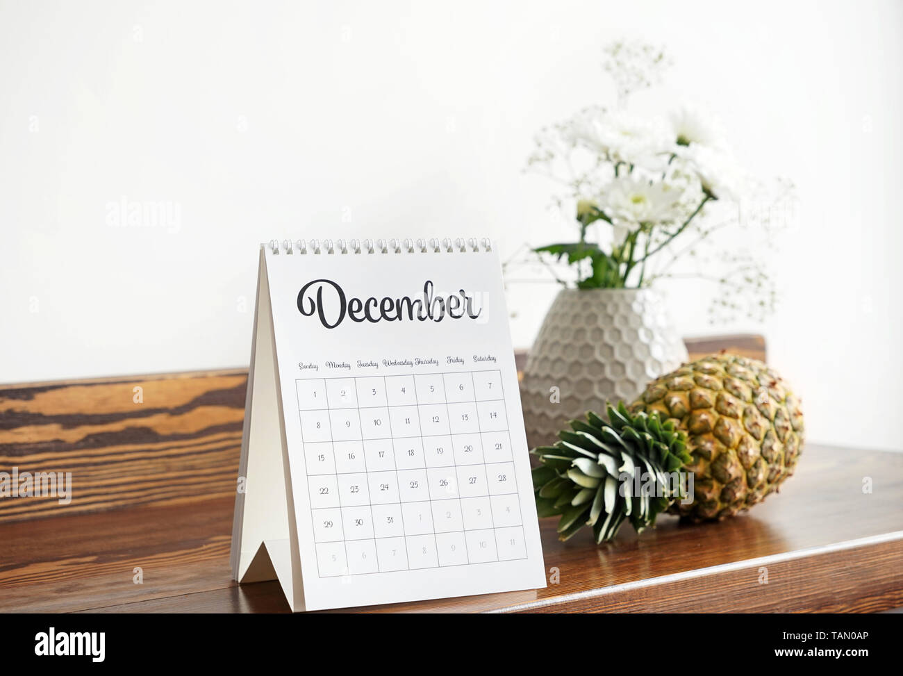 Flip calendar and decor on wooden table against white background Stock ...
