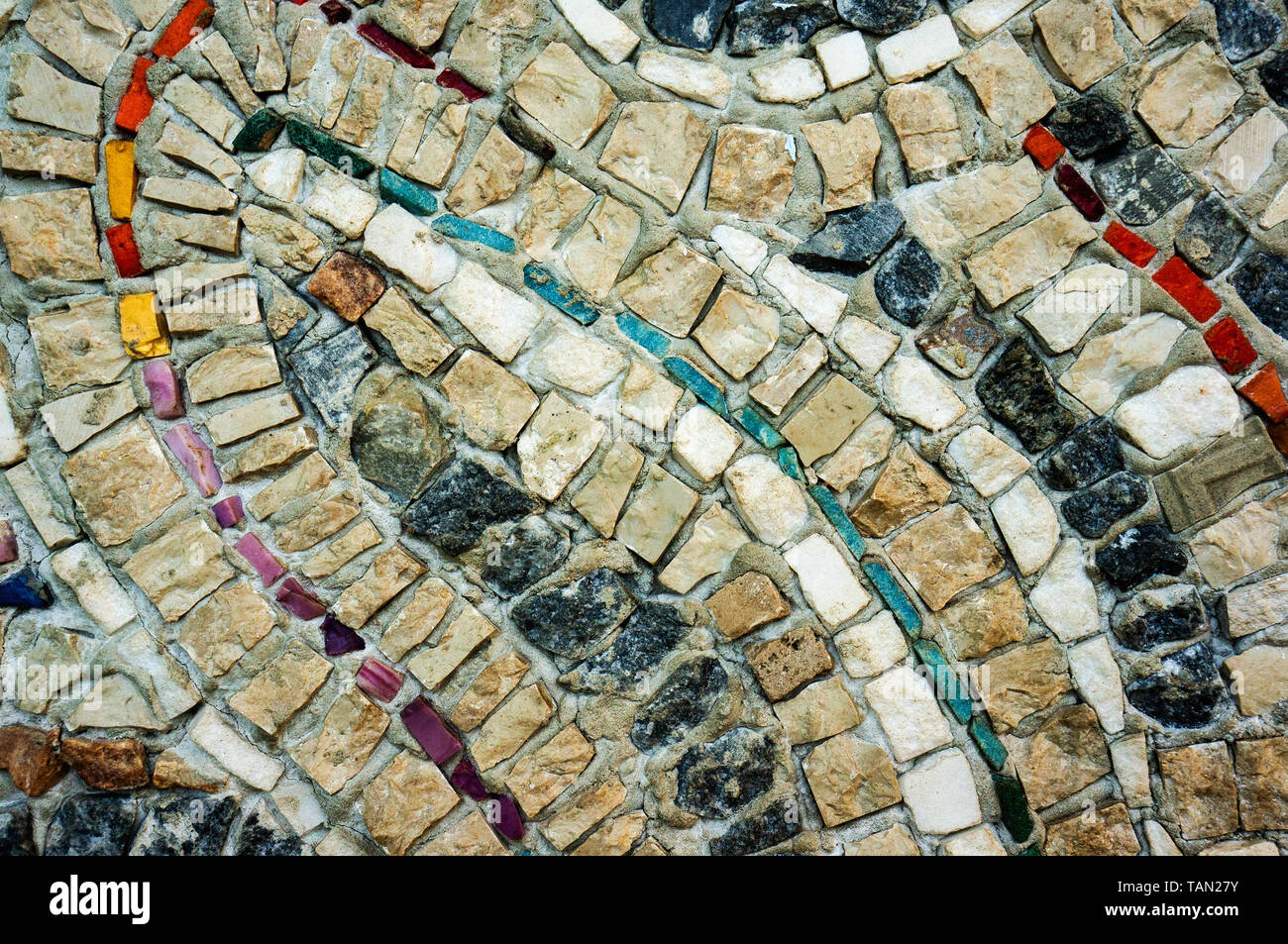 A fragment of the wall of small colored stones. The texture of the ...