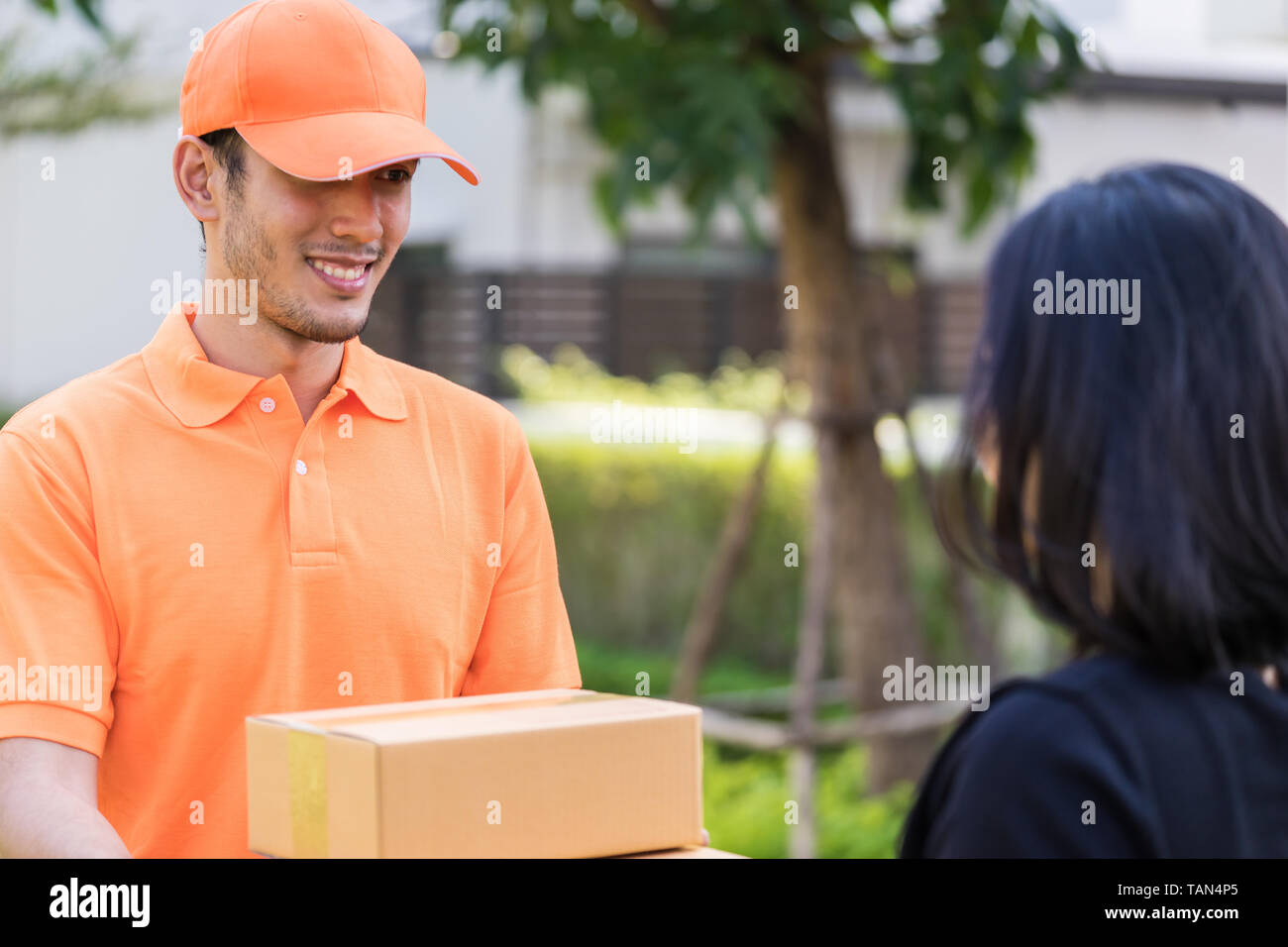 Woman receiving a delivery of box from delivery man Stock Photo - Alamy