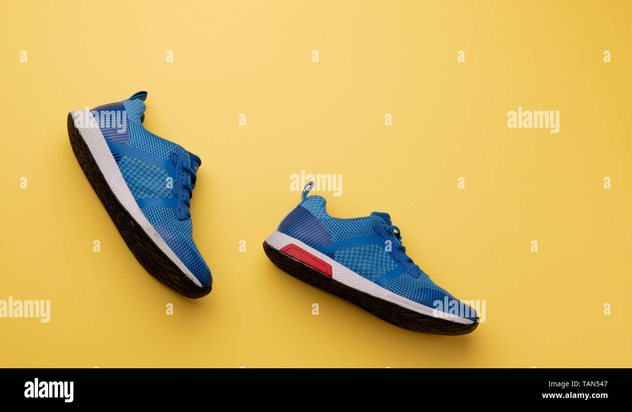 A studio shot of pair of running shoes on yellow background. Flat lay ...