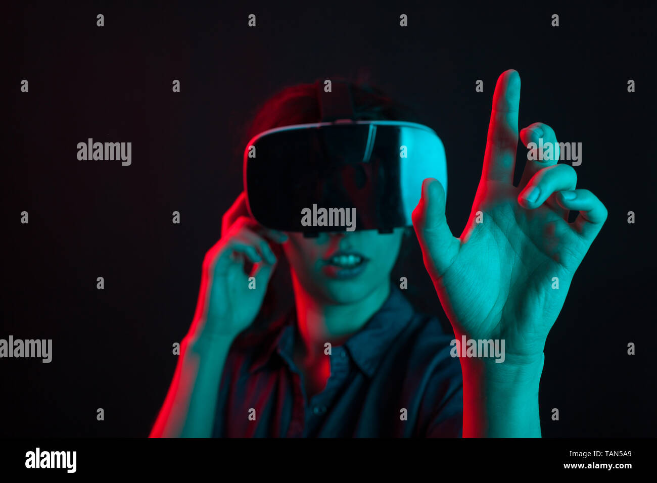 Cheerful beautiful young woman entertained with virtual reality helmet ... Cheerful beautiful young woman entertained with virtual reality helmet ...