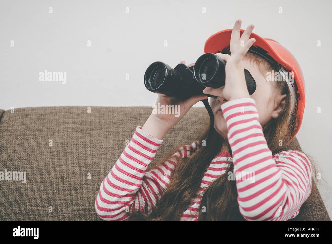 Little girl explorer is looking through binoculars Stock Photo - Alamy