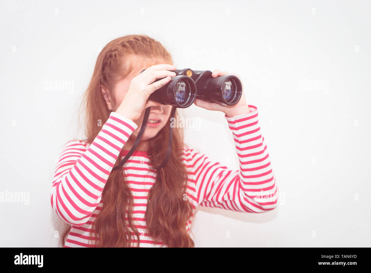 Little girl explorer is looking through binoculars Stock Photo - Alamy