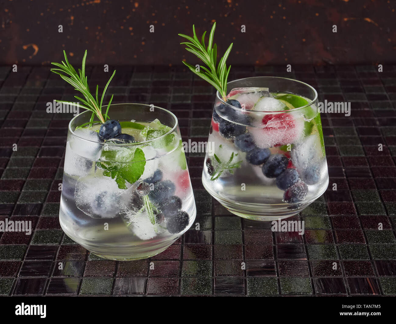 Gin tonic decorated with a rosemary sprig and fresh berries Stock Photo ...