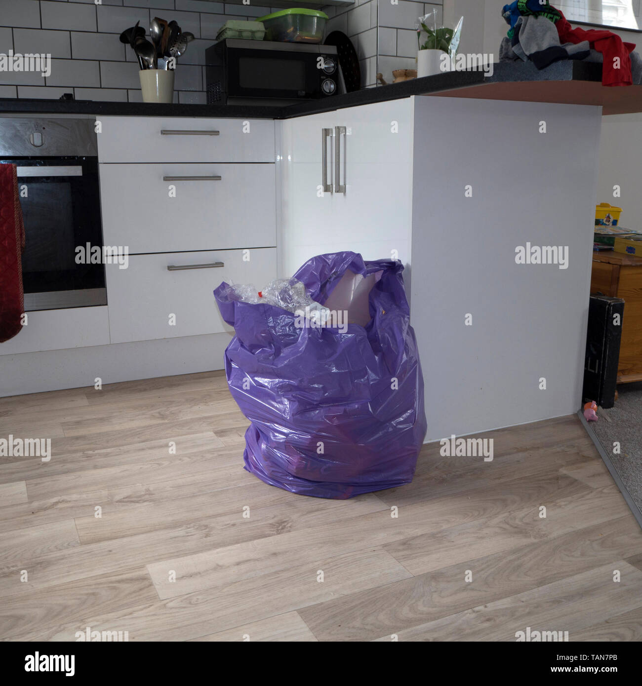 Large purple plastic bin bag in kitchen floor Stock Photo - Alamy