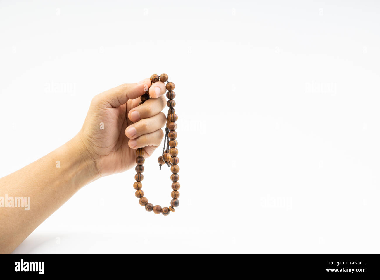 Hand holding a muslim rosary beads or Tasbih on white background. Copy ...