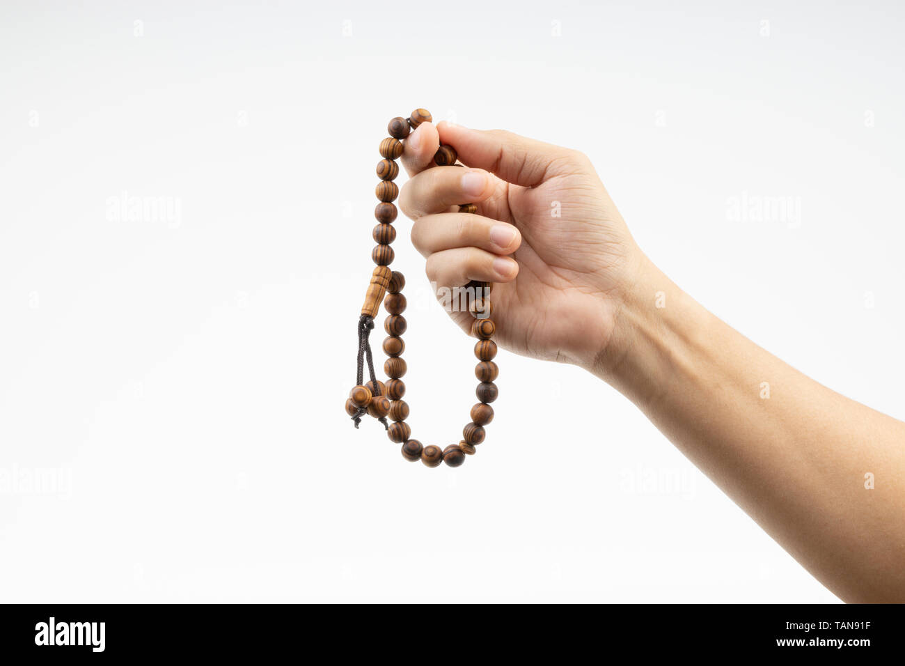 Hand holding a muslim rosary beads or Tasbih on white background. Copy ...