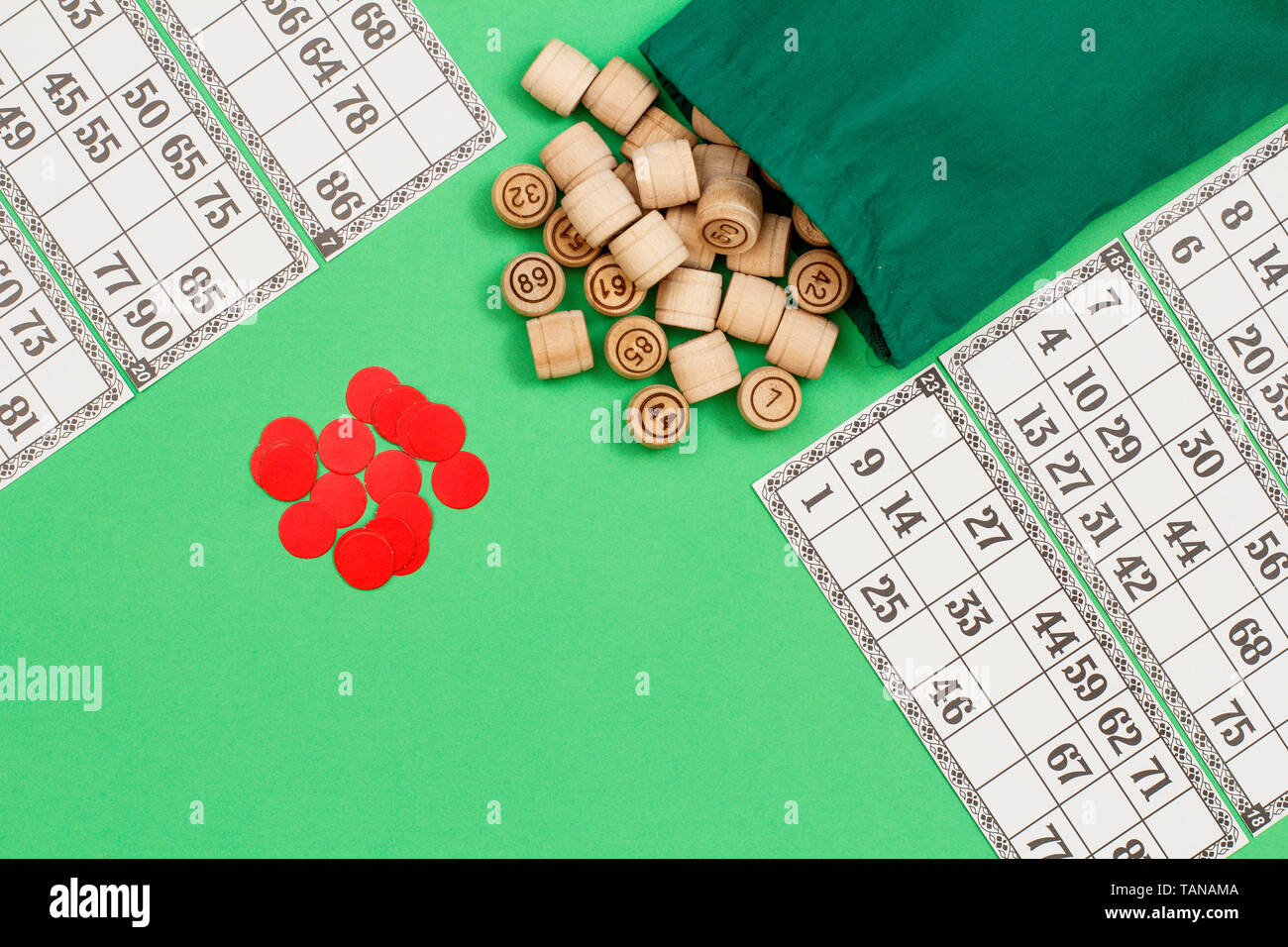 Wooden lotto barrels with cloth bag, game cards and red chips on green ...