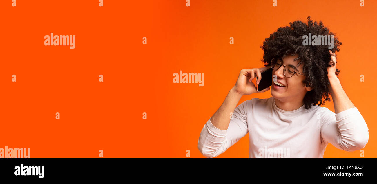 Young black man talking on phone, looking shy and embarrassed Stock ...