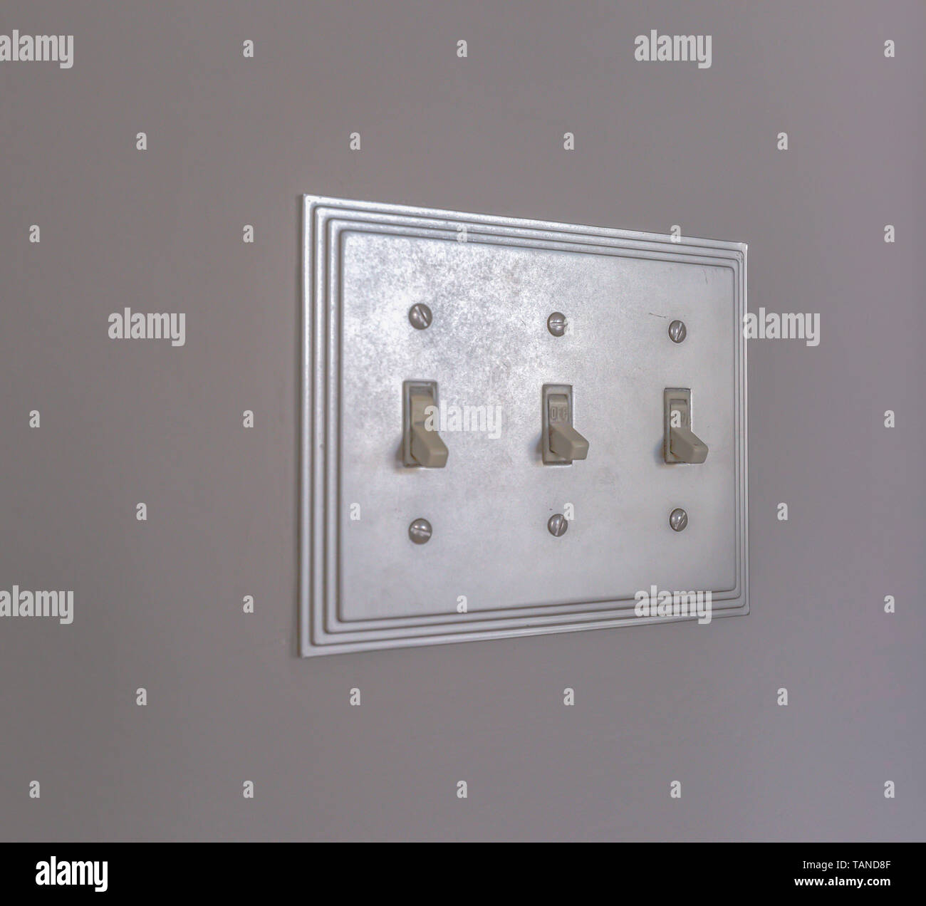 Close up of the wall mounted electrical light switch inside a house ...