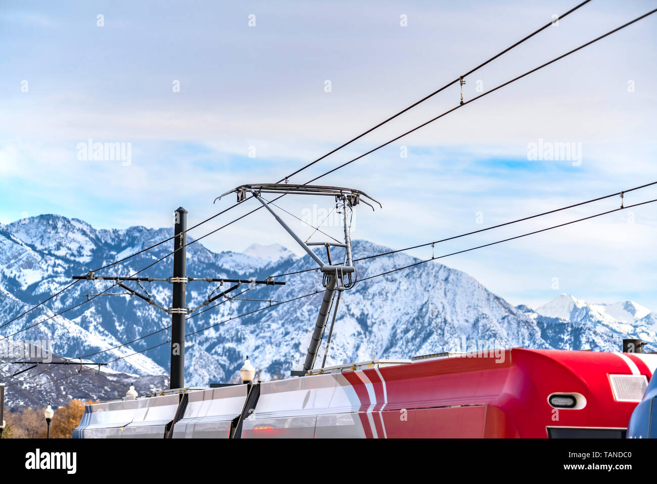 Shiny exterior of a red and white train connected to thick cable wires ...