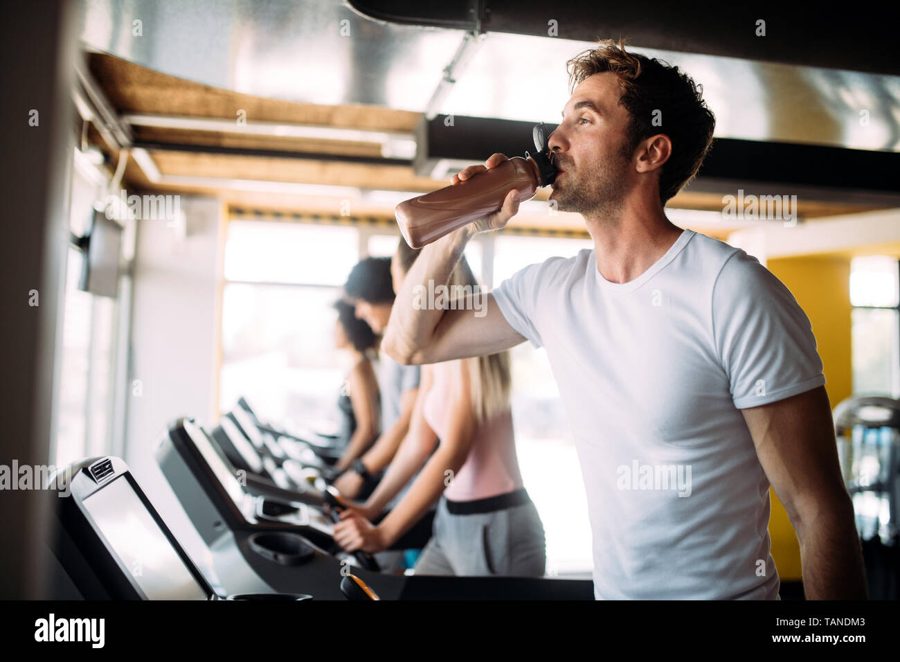 Handsome sporty man resting, having break drinking water after doing ...