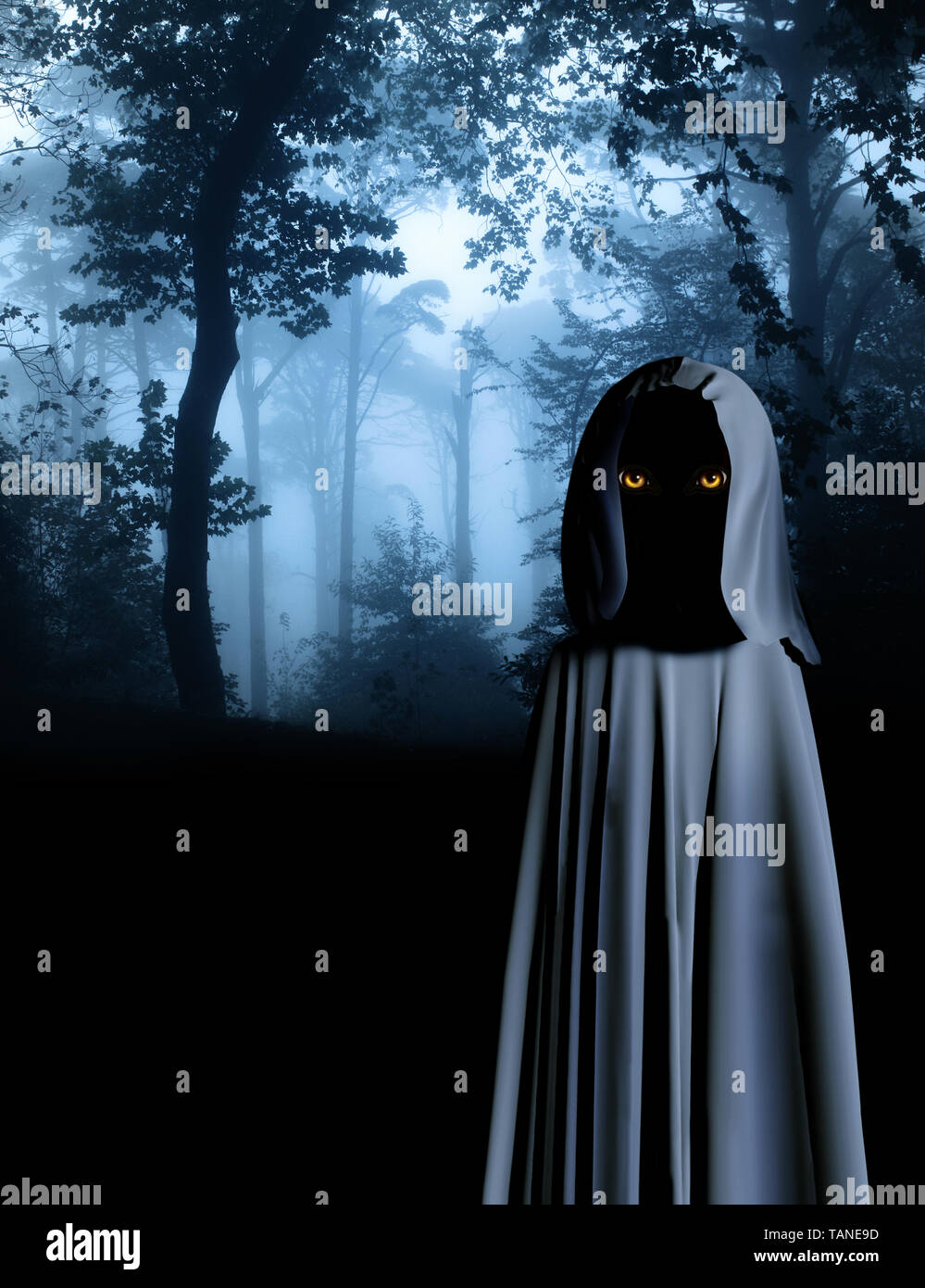 Spooky monster in hooded cloak with glowing yellow eyes in misty forest ...