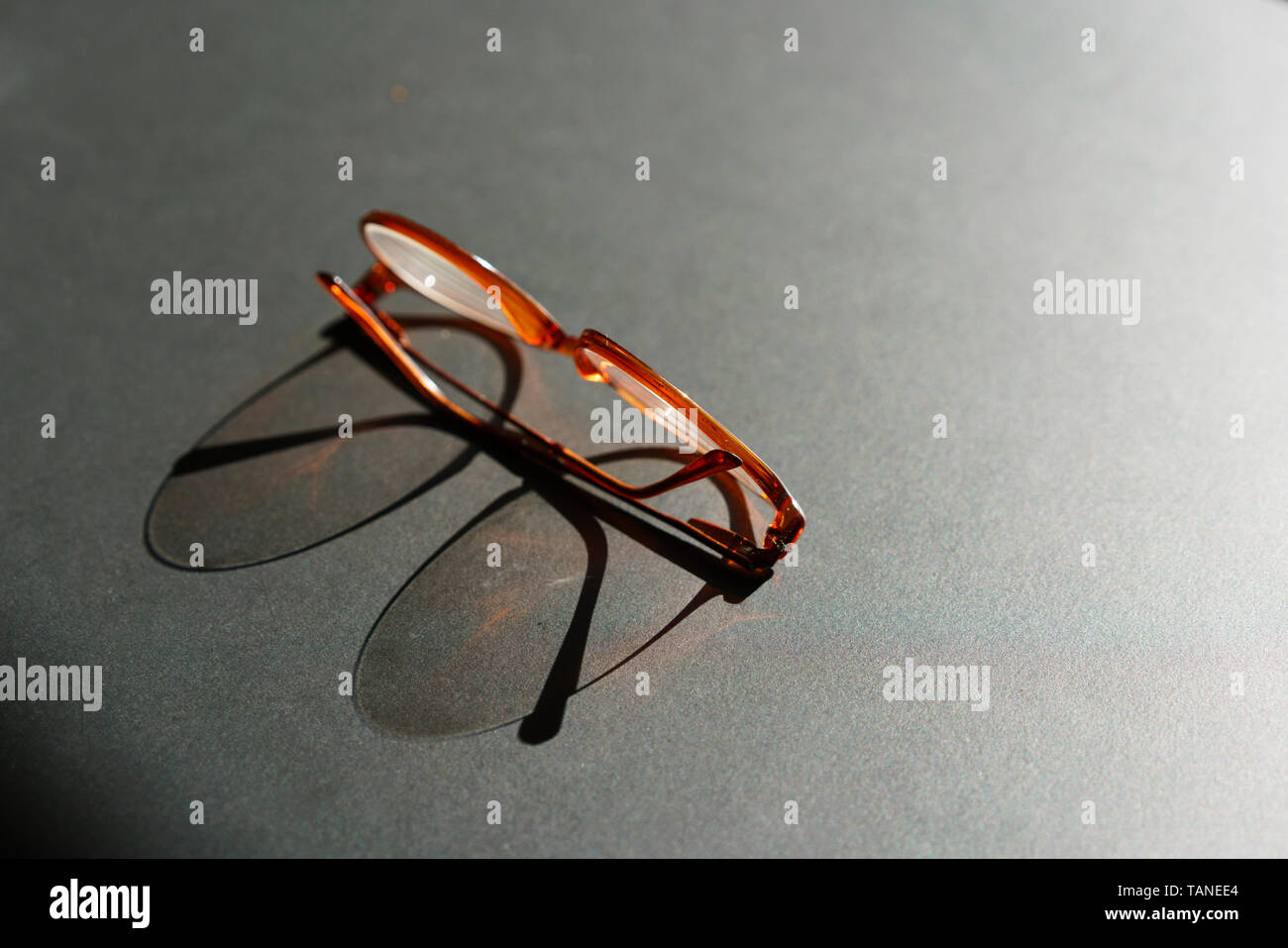 Glasses lying on a grey table and reflecting light Stock Photo - Alamy