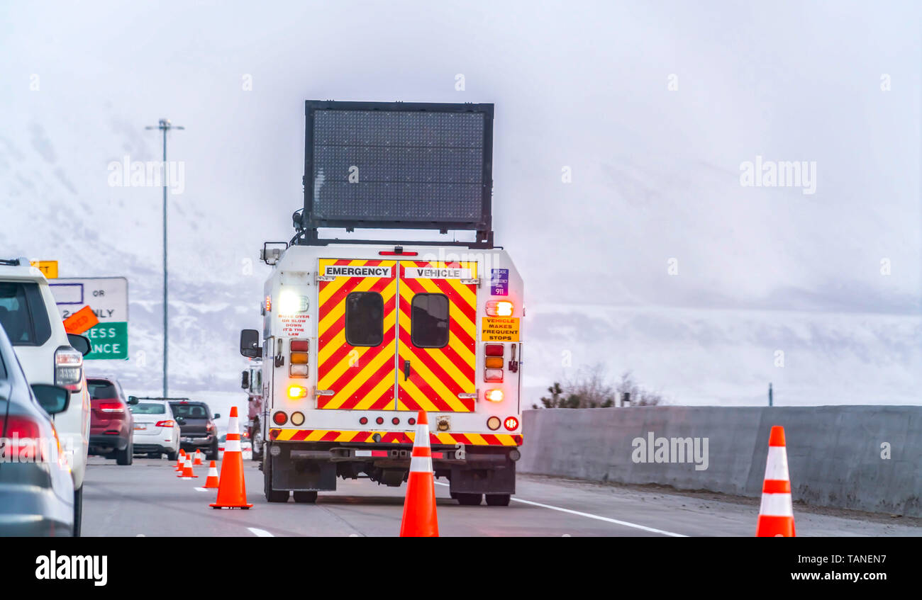 Back view of an emergency vehicle on the road with traffic cones and ...