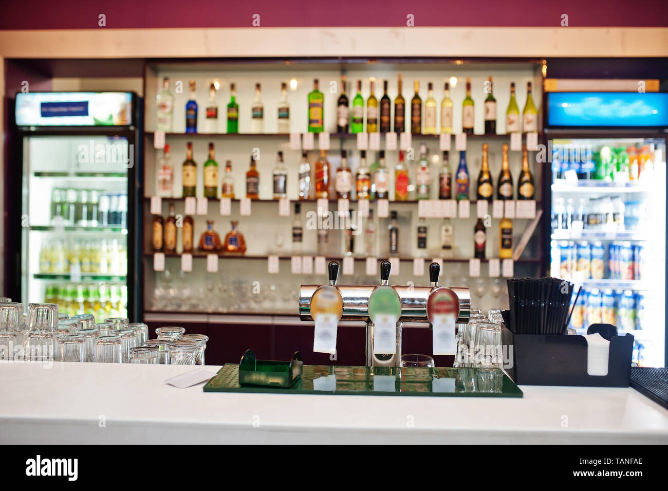 Multiple beer taps in a row against bar with bottles Stock Photo - Alamy