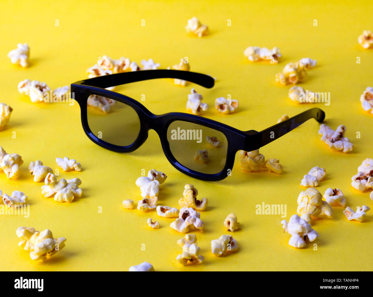 Popcorn and 3d glasses at yellow table. Concept of entertainment and ...