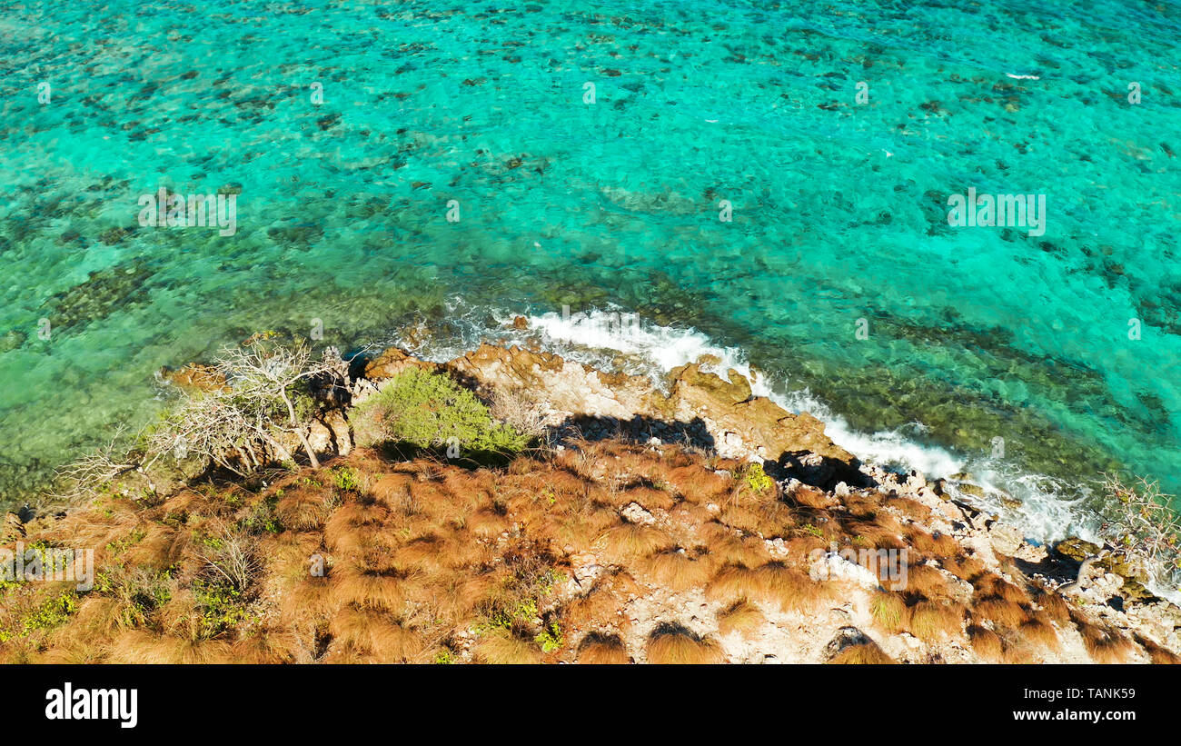 aerial view water surface with waves and coast tropical island. Lagoon ...