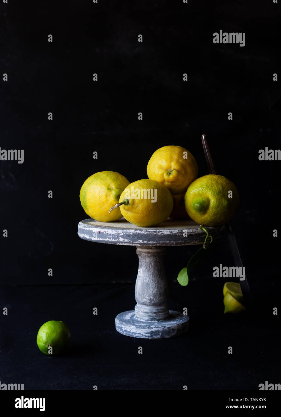 Still life with fresh yellow lemons on a stand Stock Photo - Alamy