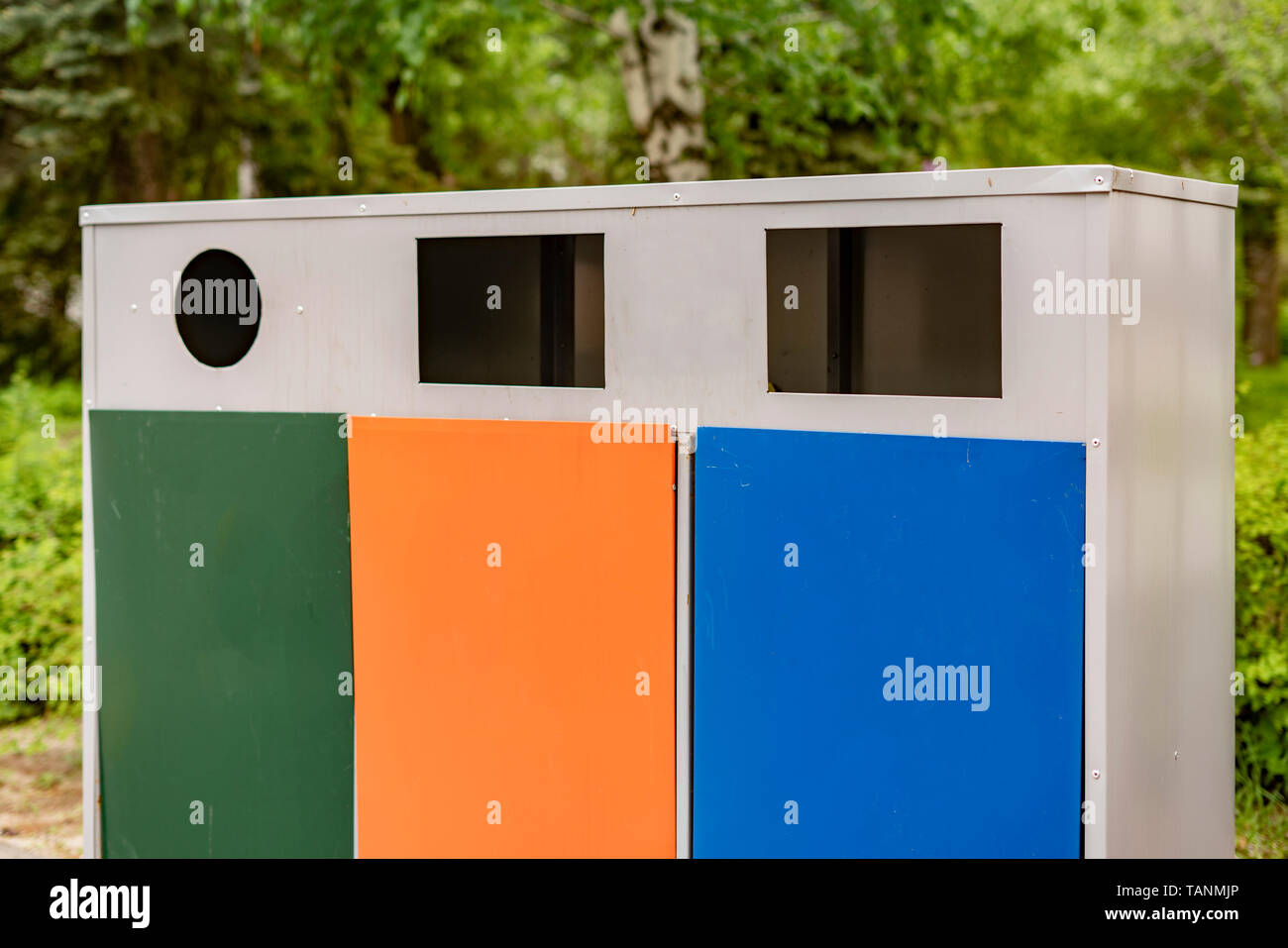 three different colorful metal trash bins or containers, garbage ...