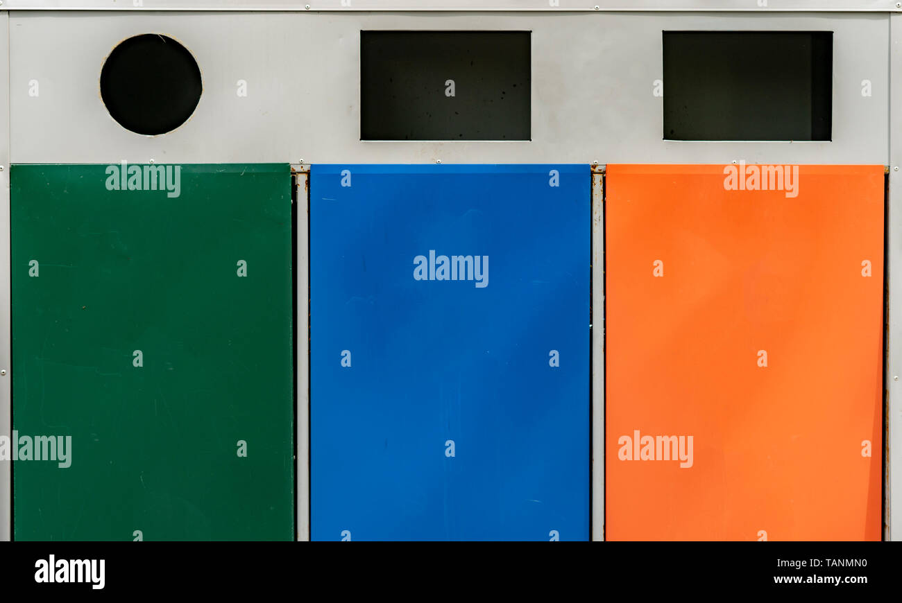 three different colorful metal trash bins or containers, garbage ...