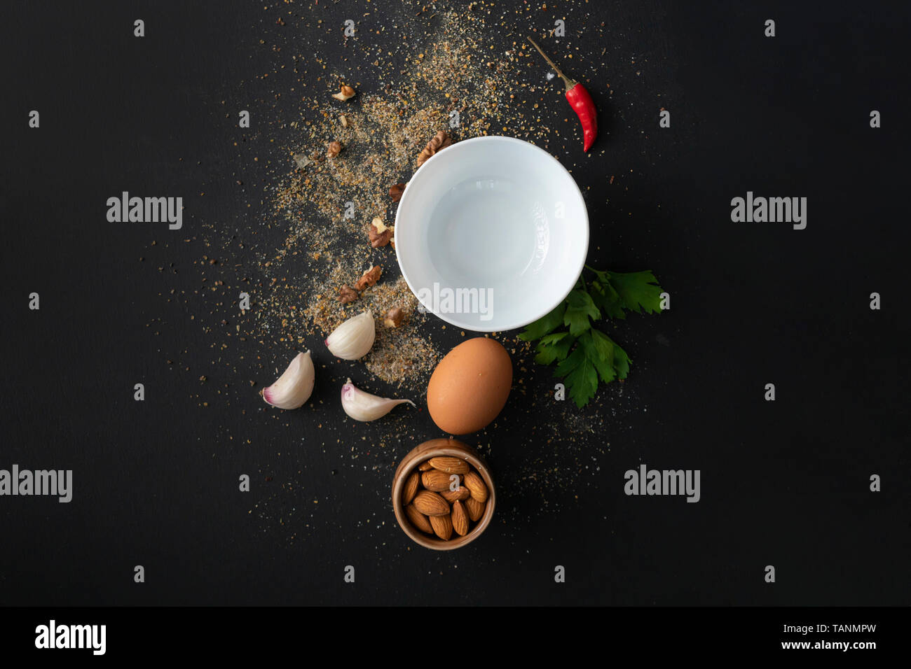empty white ceramic plate on the black table, fresh ingredients for ...
