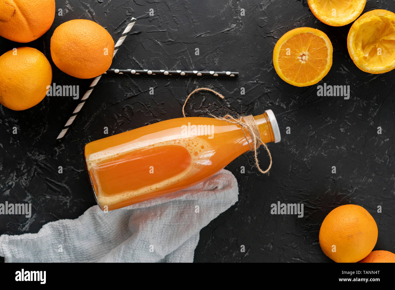 glass bottle with a squeezed orange juice, sliced in a half oranges ...