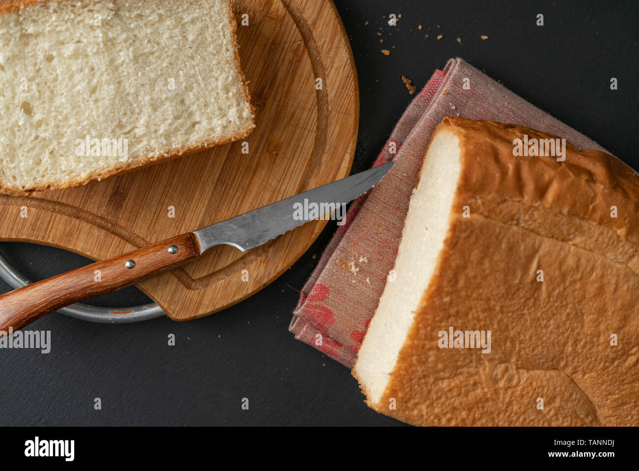 freshly baked sliced white bread with metal knife, toasts for cooking ...