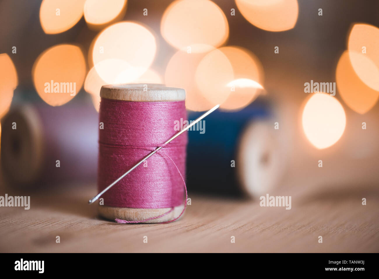 Spool of pink thread with needle closeup. Needlework Stock Photo - Alamy