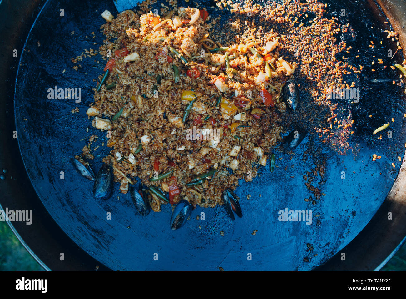 Frying paella outdoor, pan and paddle Stock Photo - Alamy