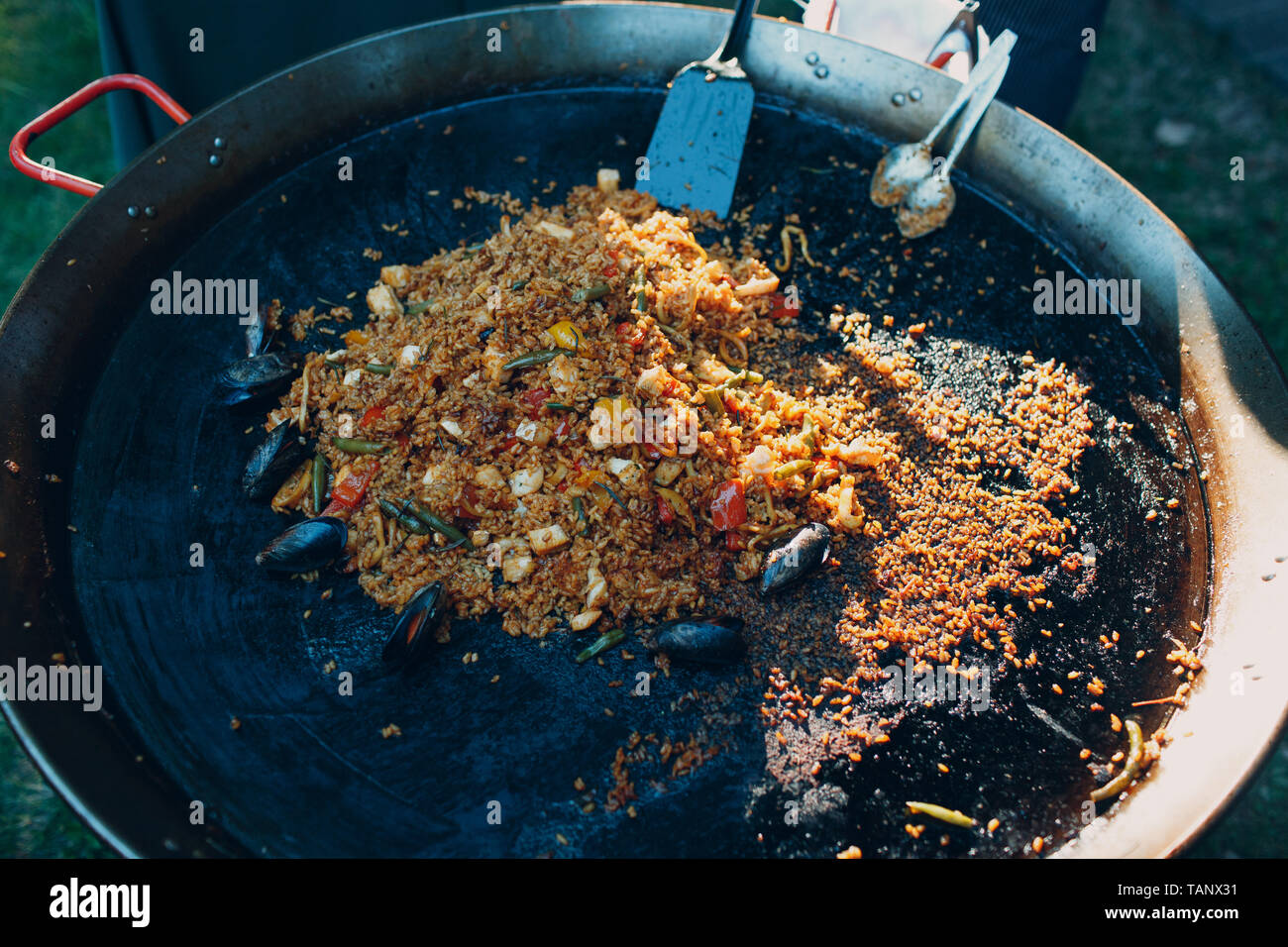 Frying paella outdoor, pan and paddle Stock Photo - Alamy