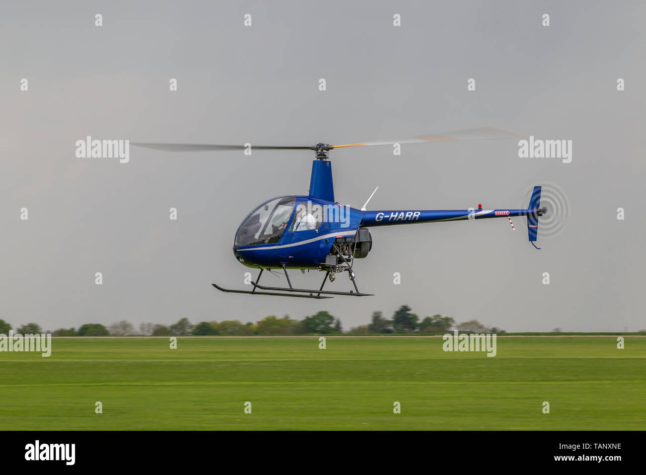A Robinson R-22 Beta helicopter flying against a dark sky during the ...