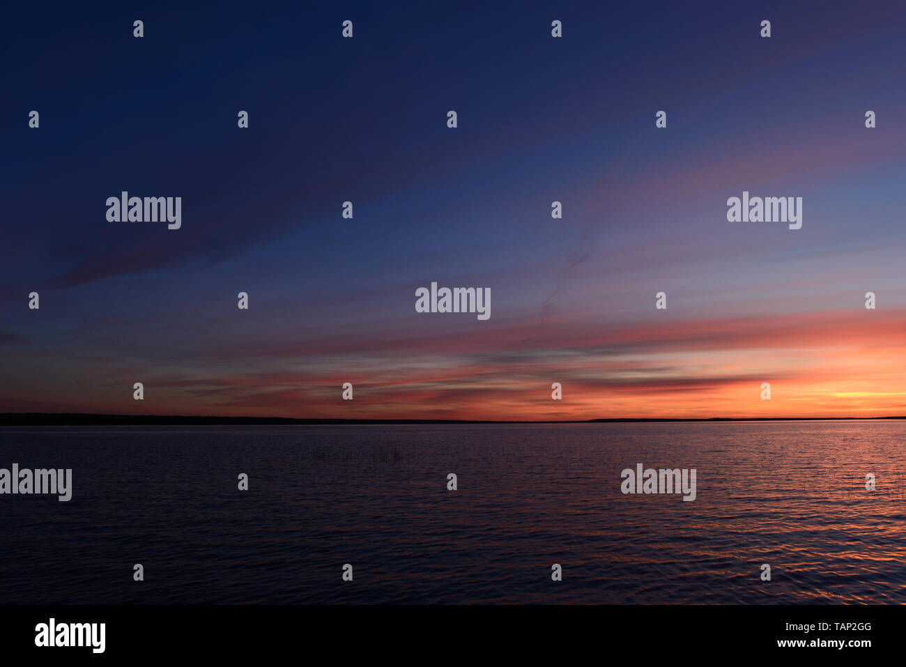 Twilight sunset glow in a cloudy haze of nightfall bright blue sky on ...