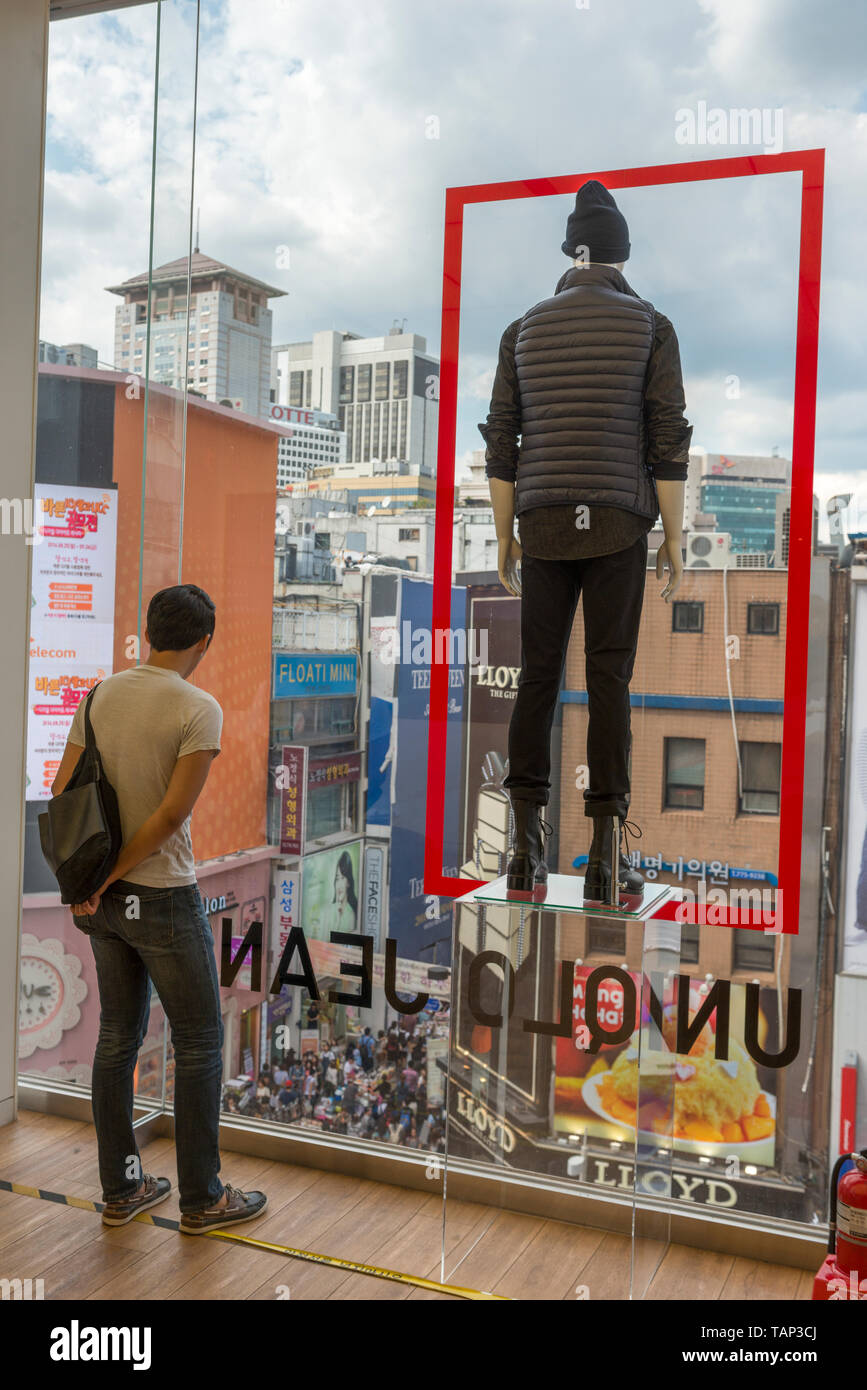 Man standing in store, looking through glass window, Seoul, South Korea ...