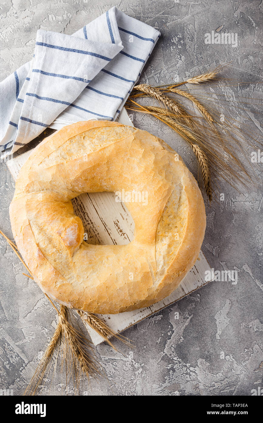 Wheat round bread in the form of a ring and spikelets on a wooden ...