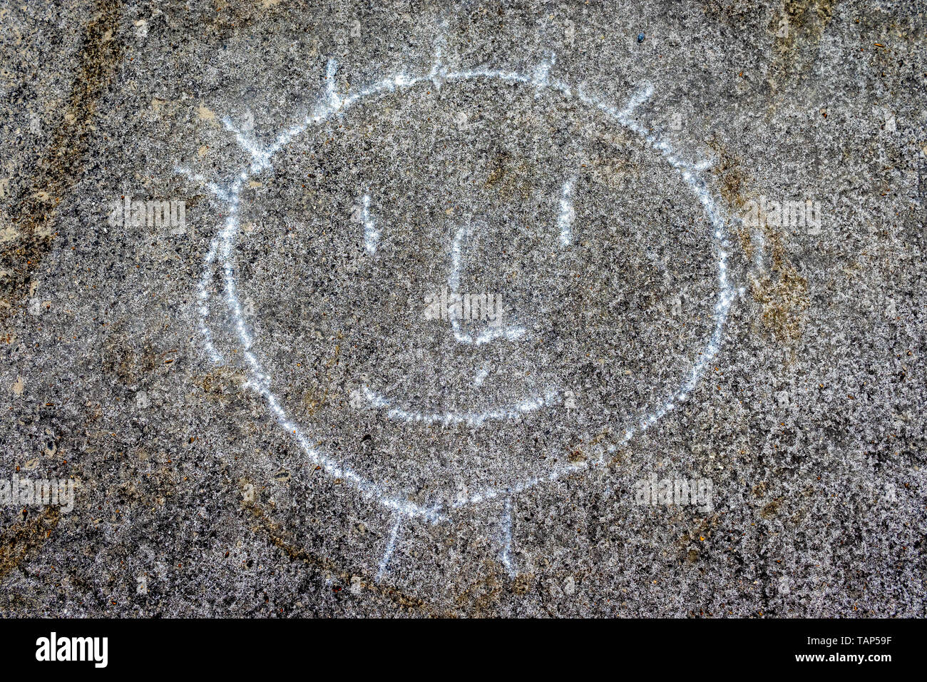 Child's chalk drawing of a face on the floor Stock Photo - Alamy
