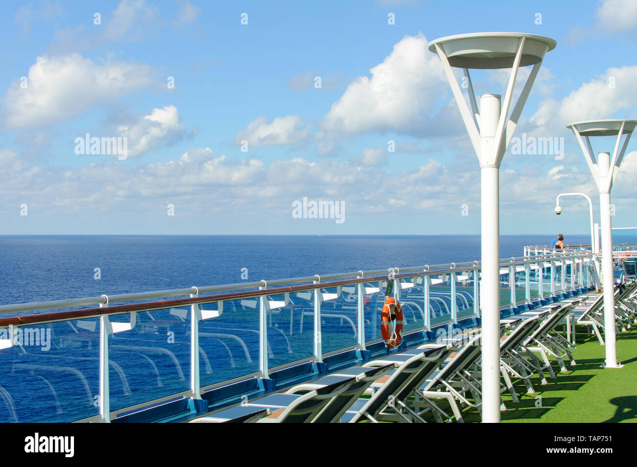 View from the deck of a cruise ship in the ocean. Seating area for ...