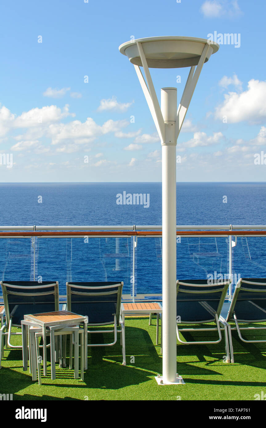 View from the deck of a cruise ship in the ocean. Seating area for ...
