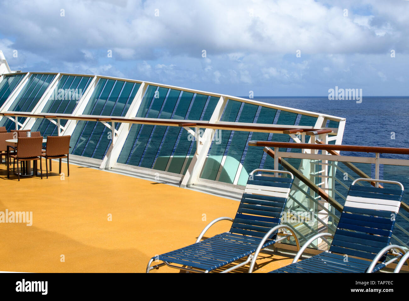 View from the deck of a cruise ship in the ocean. Seating area for ...