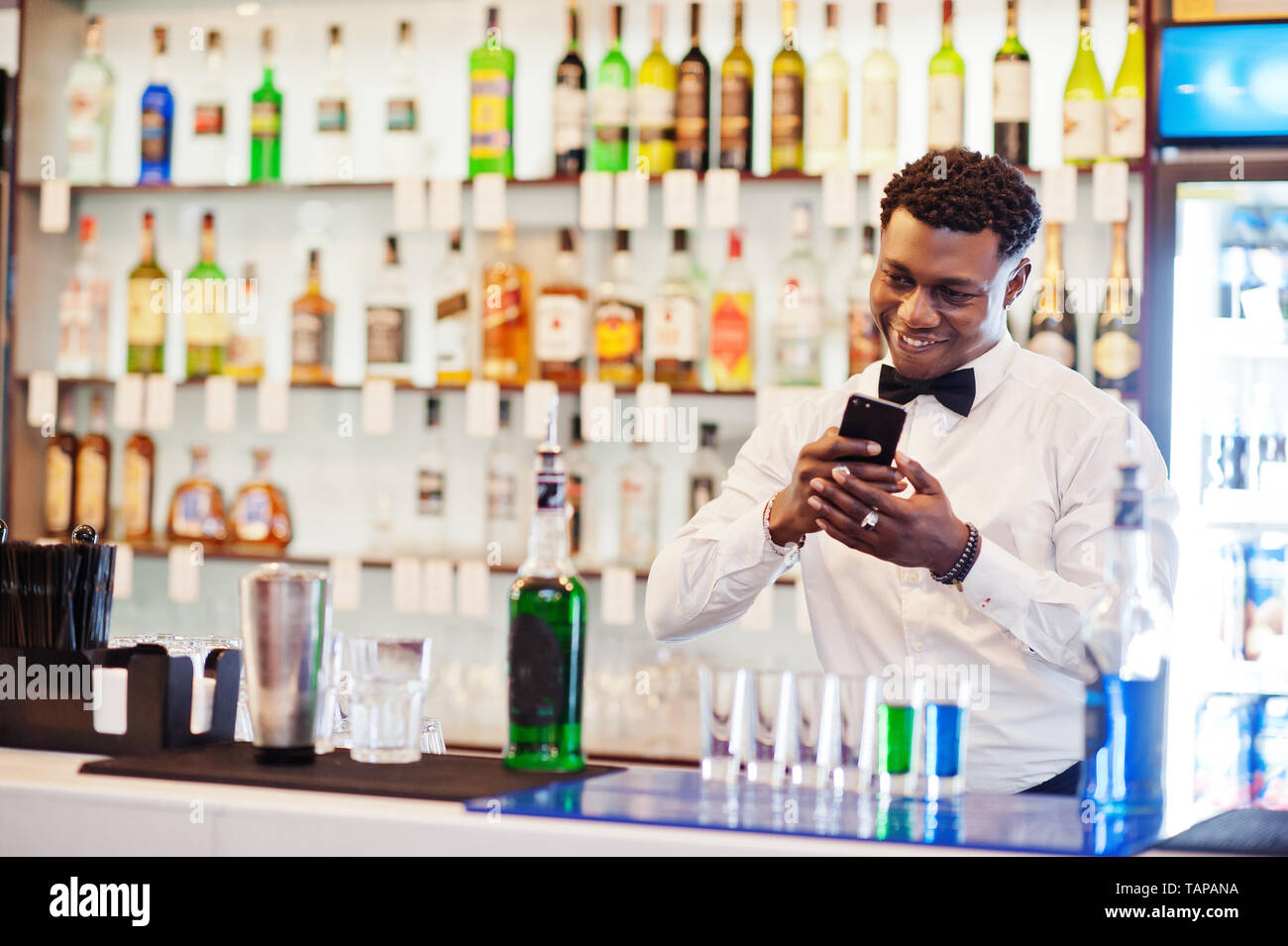African american bartender at bar making coctails on shots and shoot ...