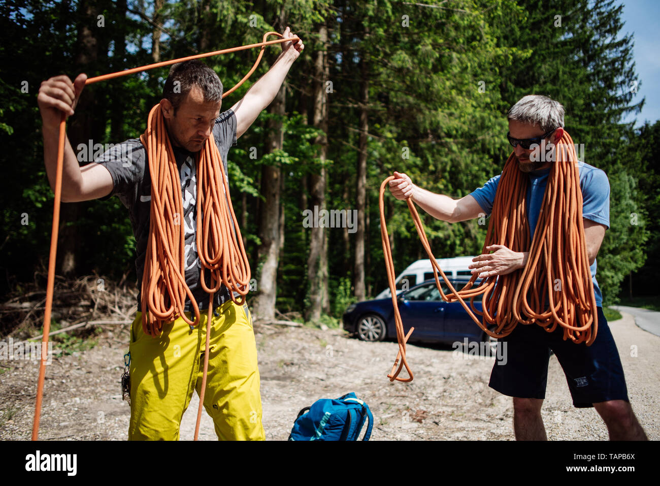 Two climbers folding their ropes and preparing to go climbing Stock ...
