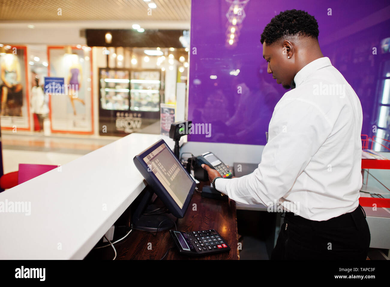 African american bartender at bar uses a credit card terminal on ...