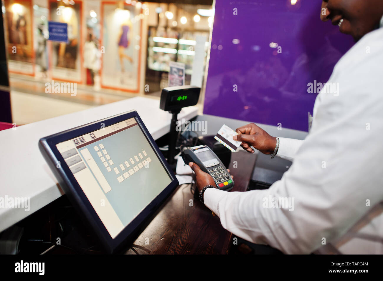 African american bartender at bar uses a credit card terminal on ...
