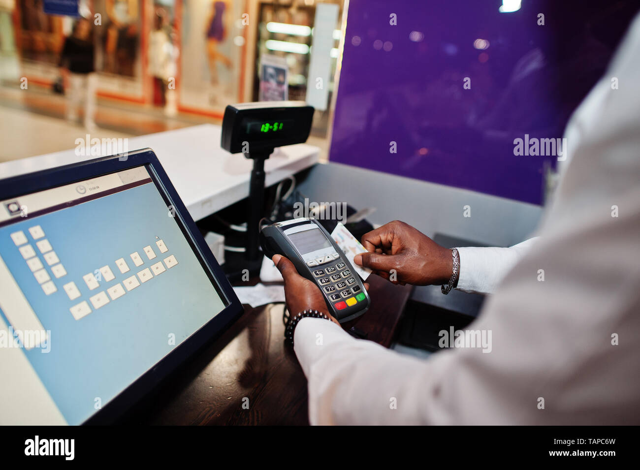 African american bartender at bar uses a credit card terminal on ...